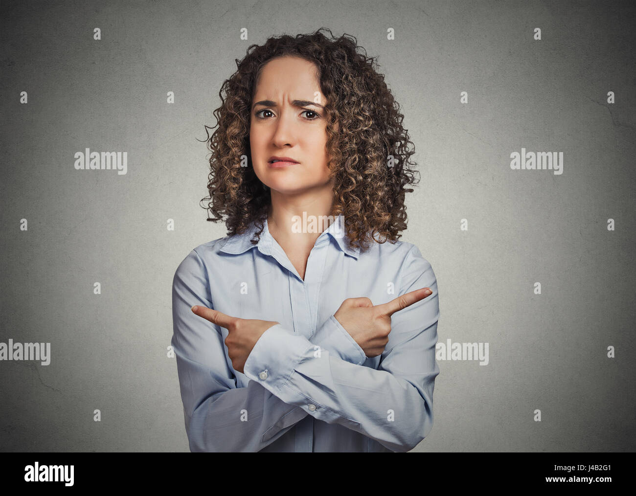 Indecision confusion. Portrait confused young woman pointing in two ...