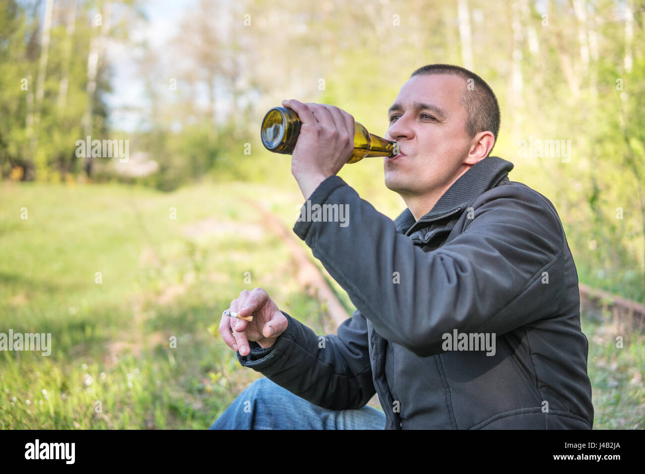 Man drinking beer smoking cigarette hi-res stock photography and images ...