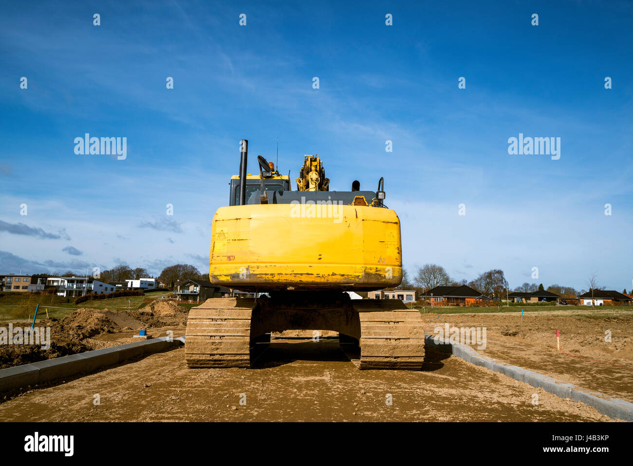 Rear end of an excavator machine on a neighborhood construction site on ...