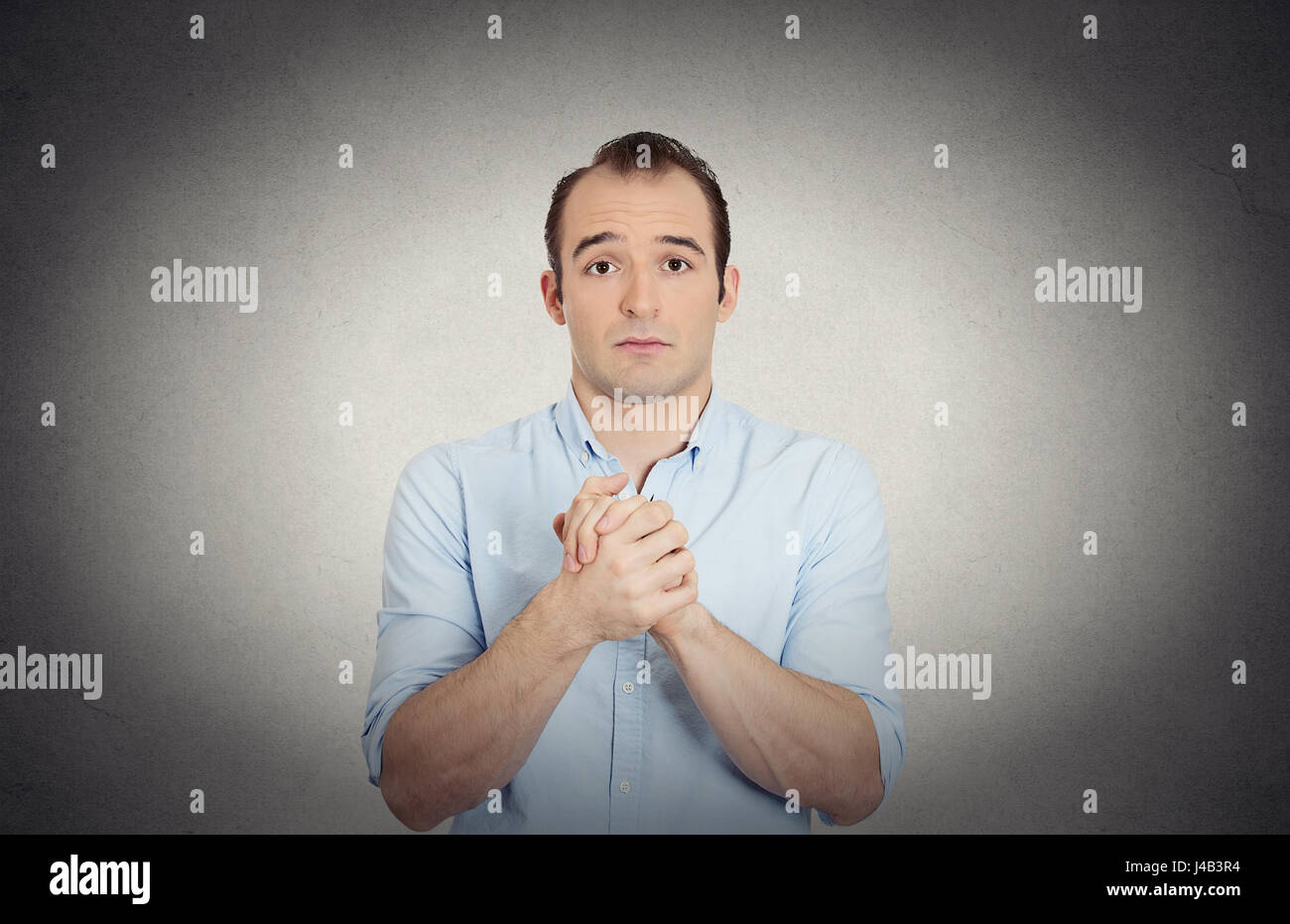 Closeup portrait desperate young man showing clasped hands, pretty ...
