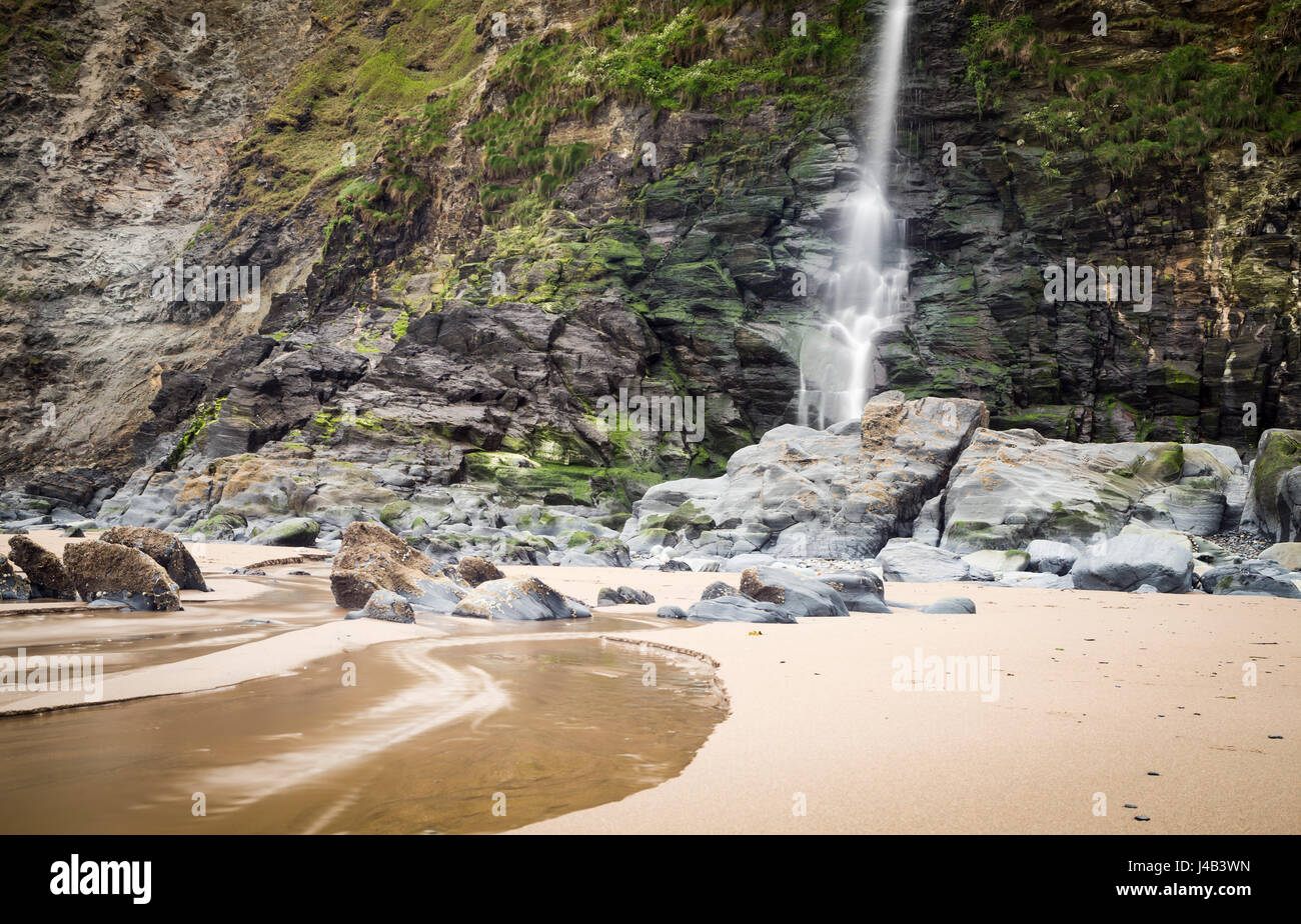Waterfall of the River Saith flows over cliffs on the beach at Tresaith ...