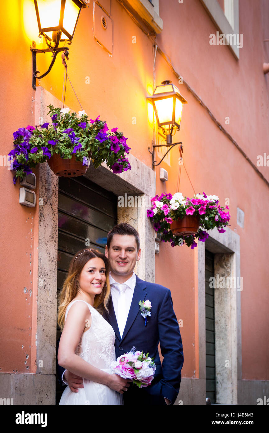 Bride and groom posing on the old streets of Rome, Italy Stock Photo ...