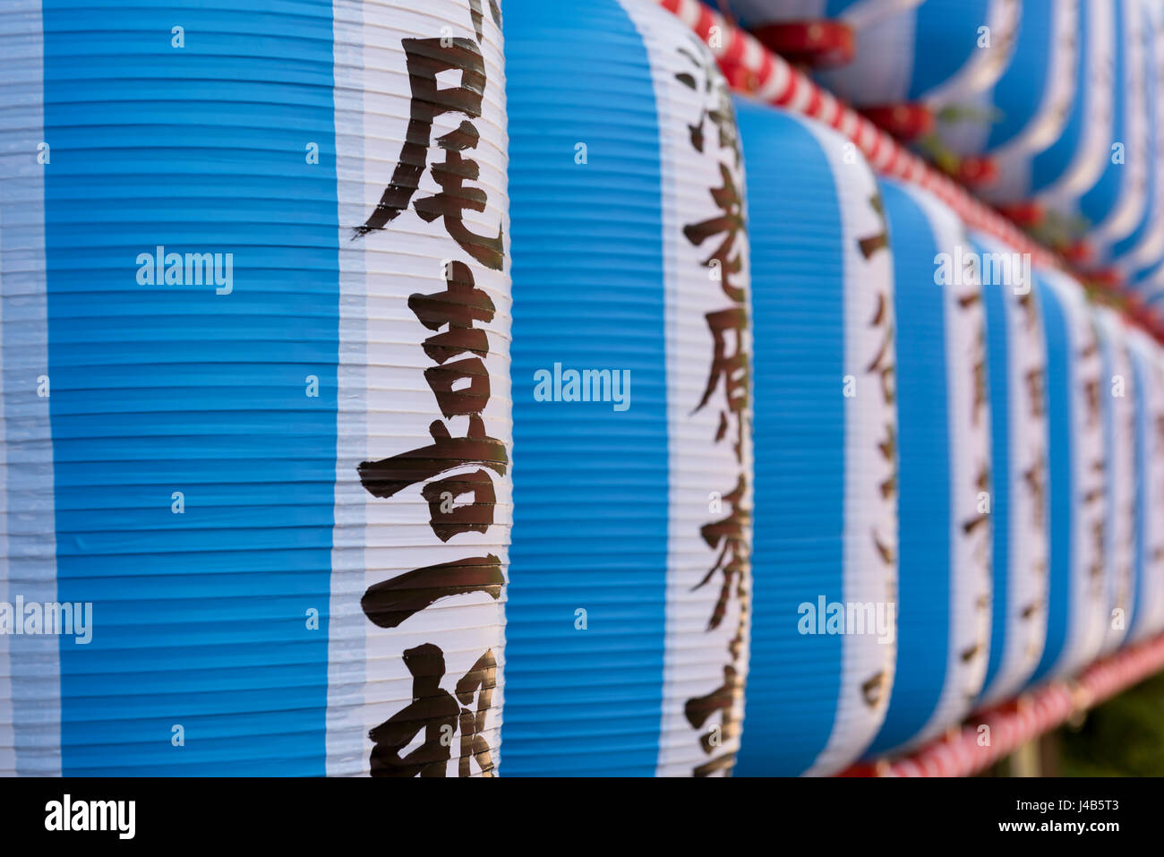 Row of traditional blue and white paper lanterns with Japanese script ...