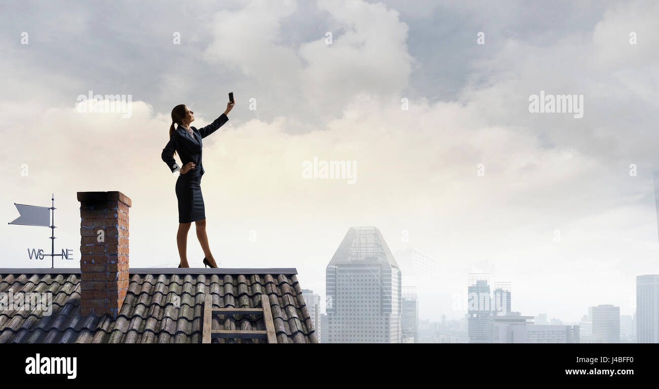 Woman on roof doing selfie Stock Photo - Alamy