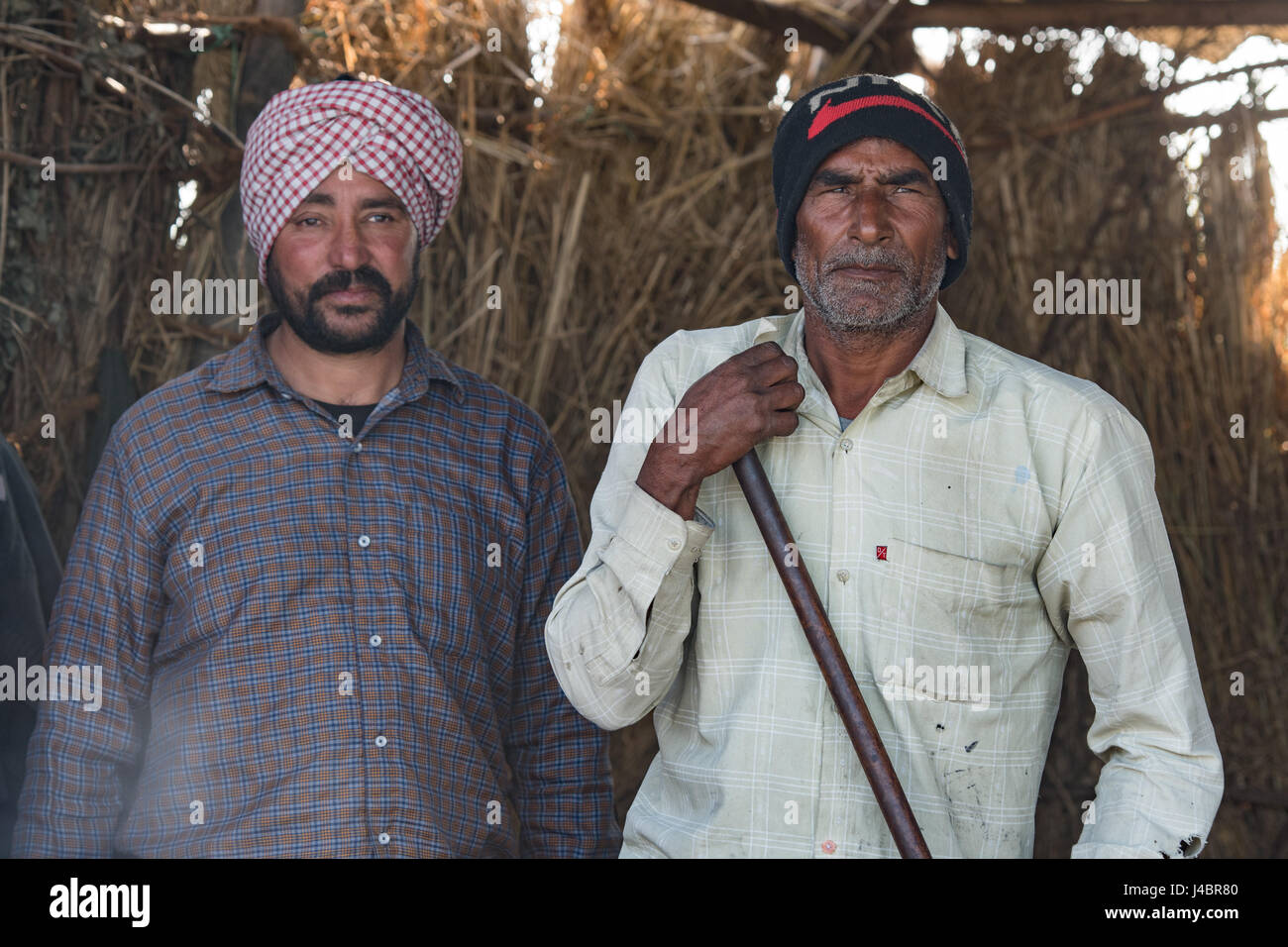 Two farm workers pose for a photograph on a farm in Punjab, India Stock ...