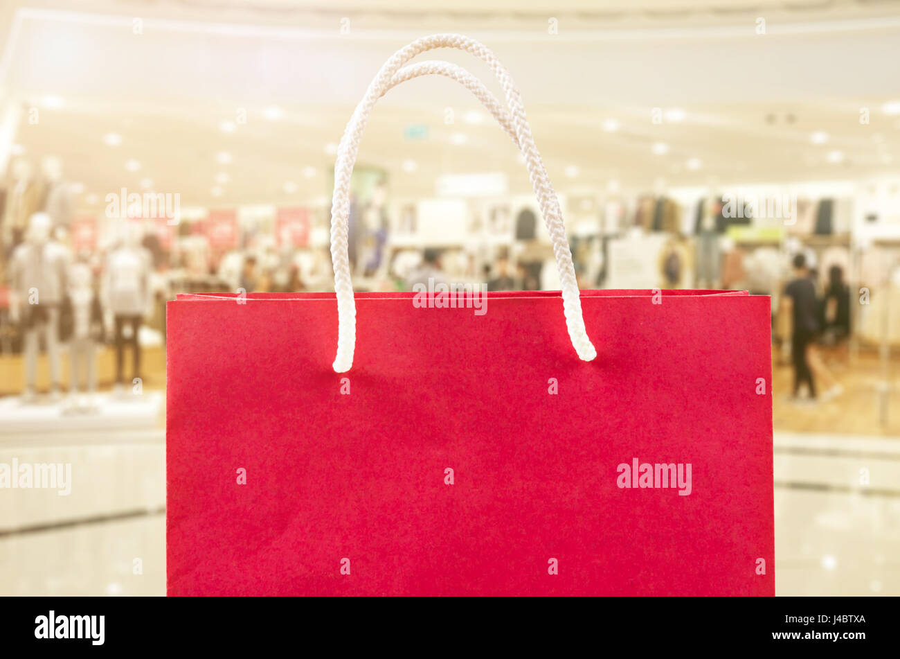 red shopping bag on over blurred mall background Stock Photo - Alamy