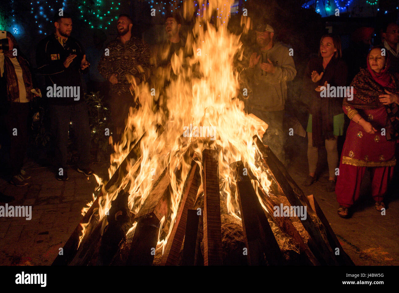 Punjabi men and women gather around a large bonfire in celebration of ...