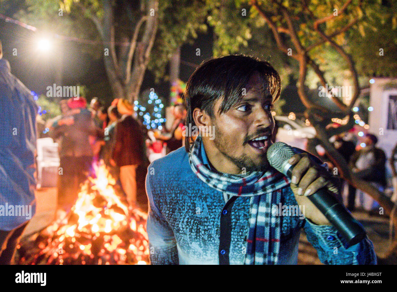 Man dressed in traditional Indian garb sings into the microphone at the ...