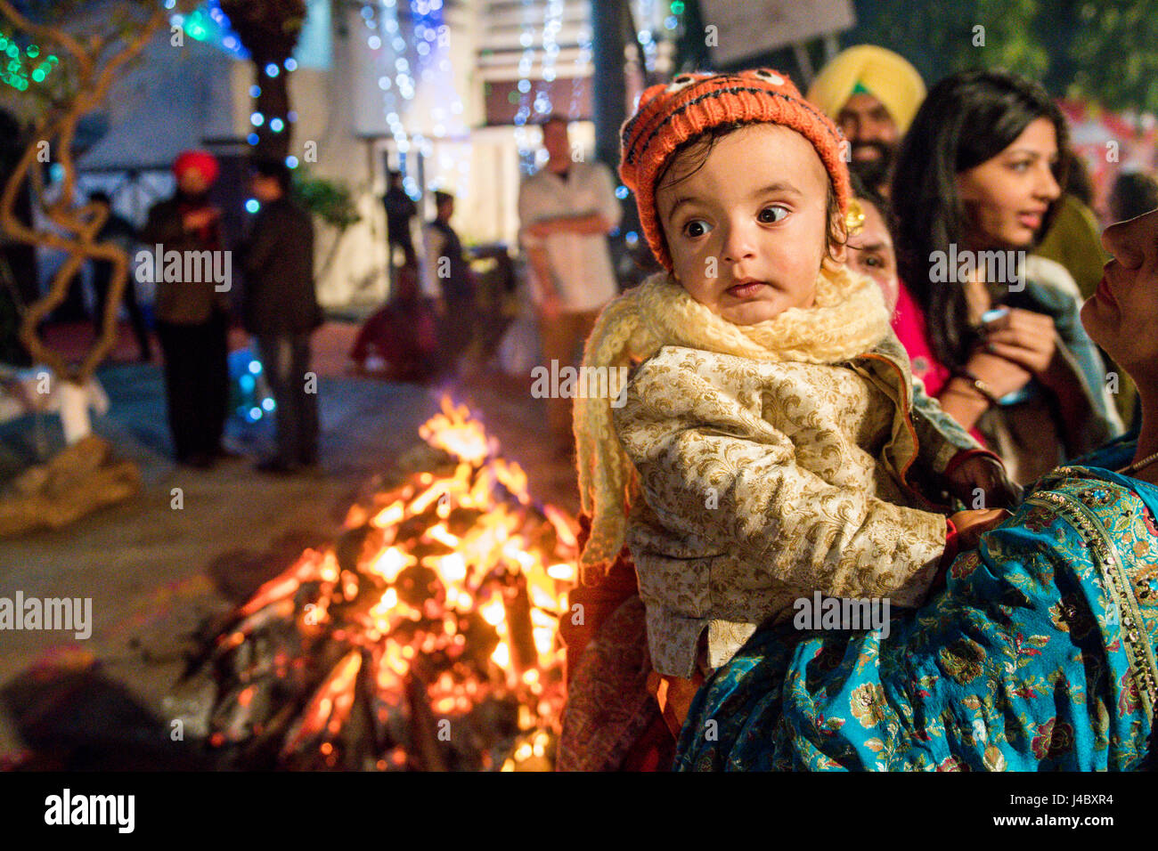 A young child looks over their shoulder at the Lohri celebration in ...