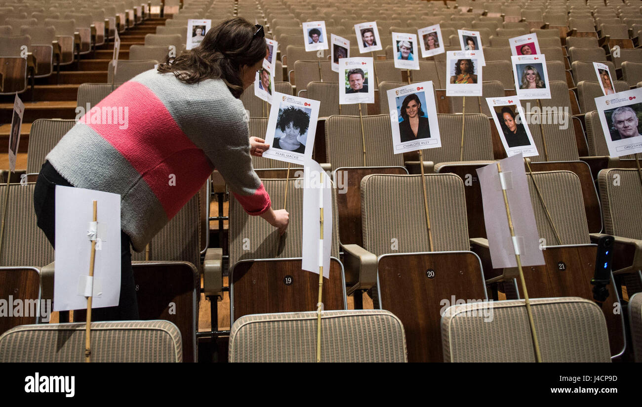 A staff member uses "heads on sticks" to check camera blocking for the ...