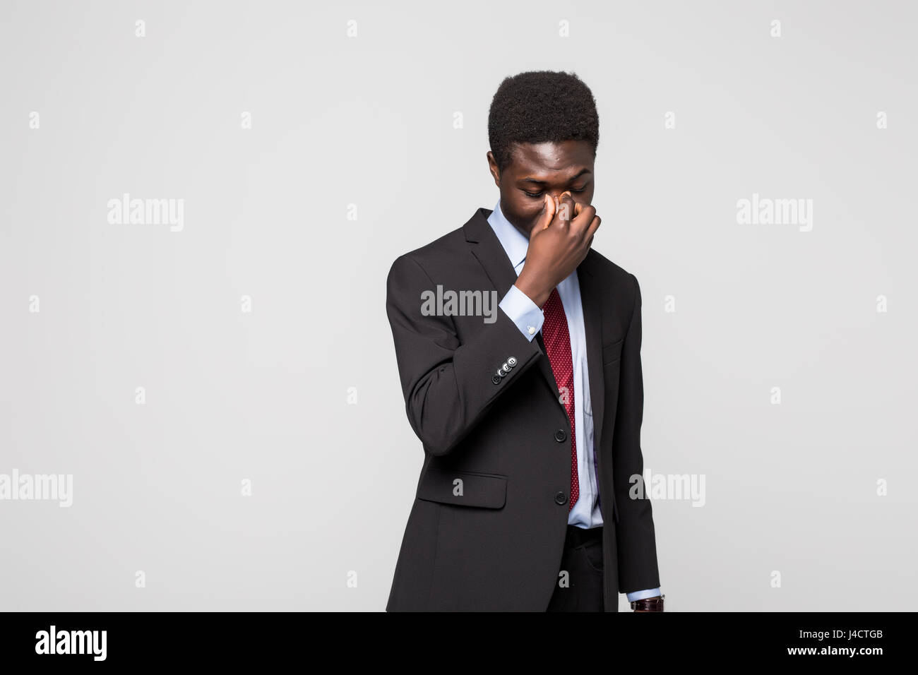 Stressed and tired. Frustrated young African man massaging nose and ...