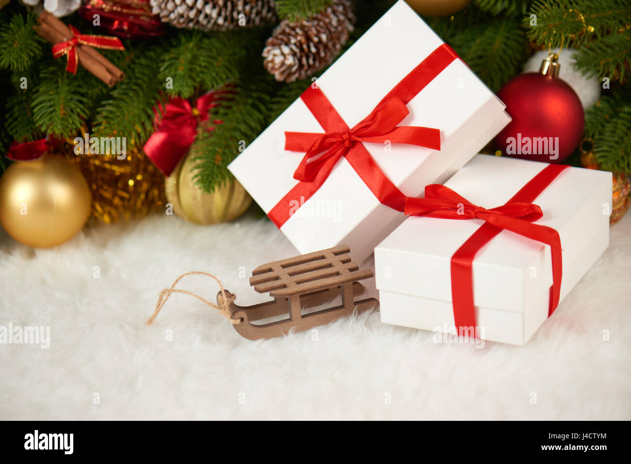 christmas decoration on fir tree branch closeup, wooden sledge toy ...