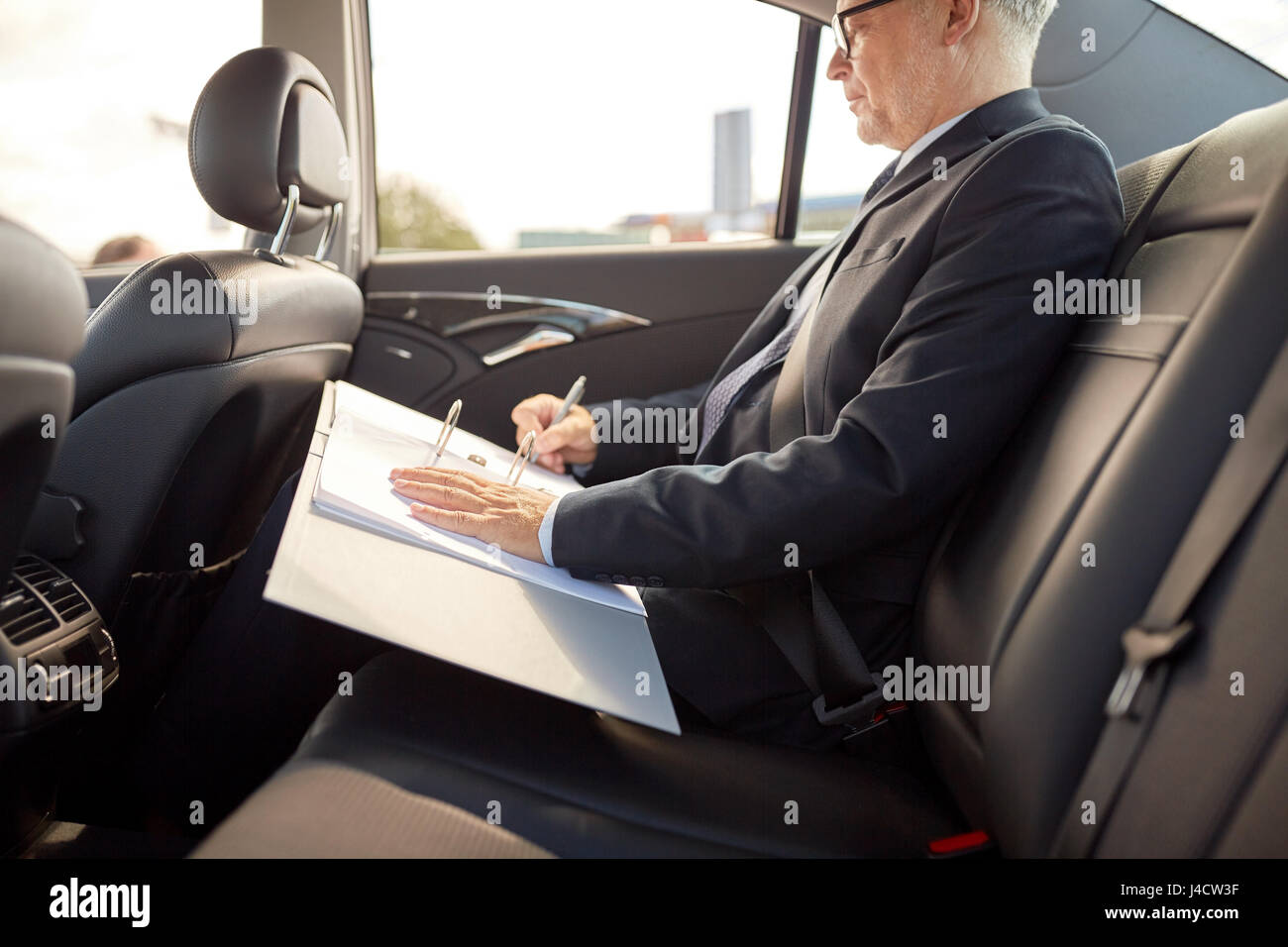 senior businessman with papers driving in car Stock Photo - Alamy