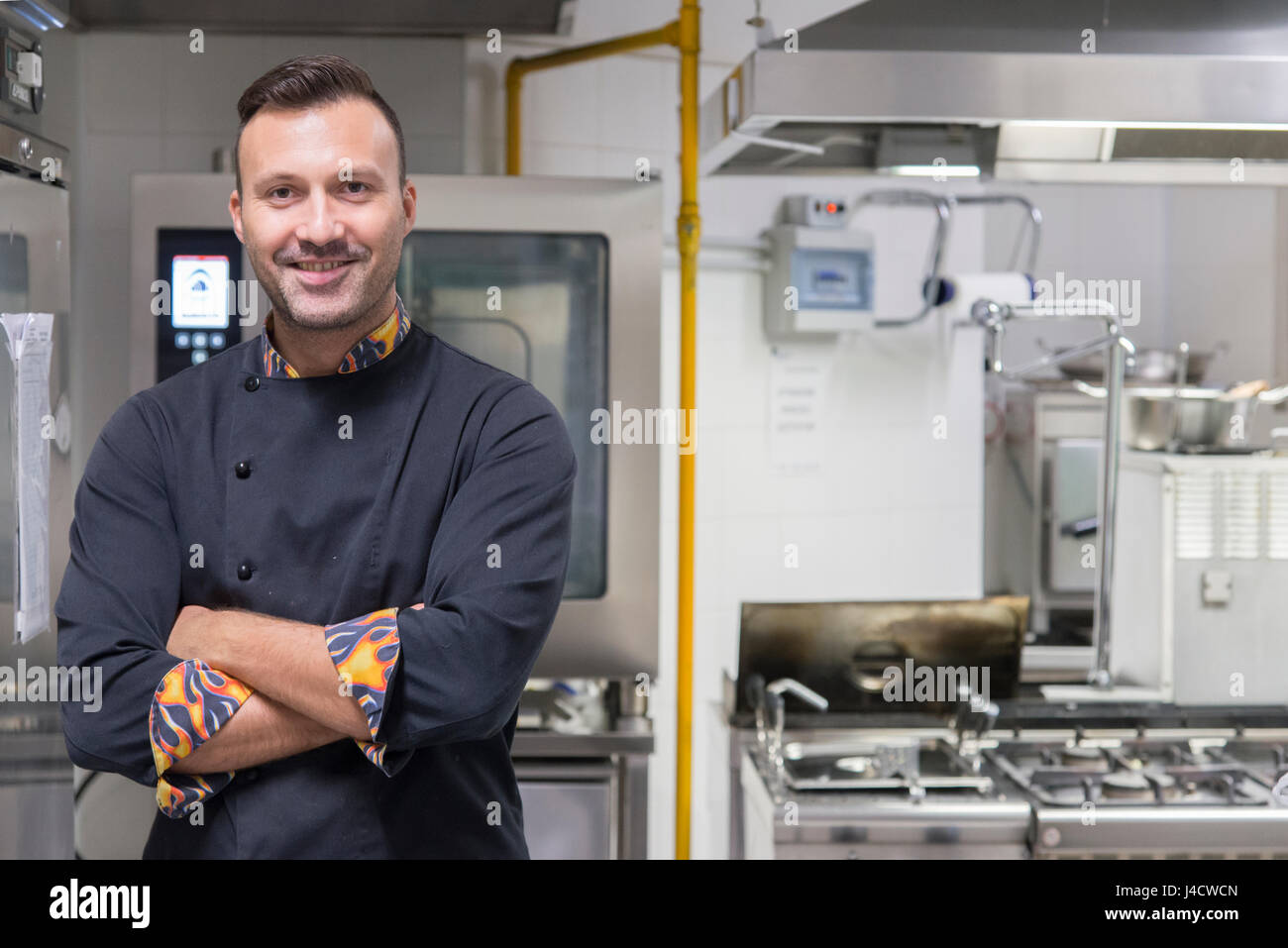 young caucasian chef into kitchen smiling at camera Stock Photo - Alamy