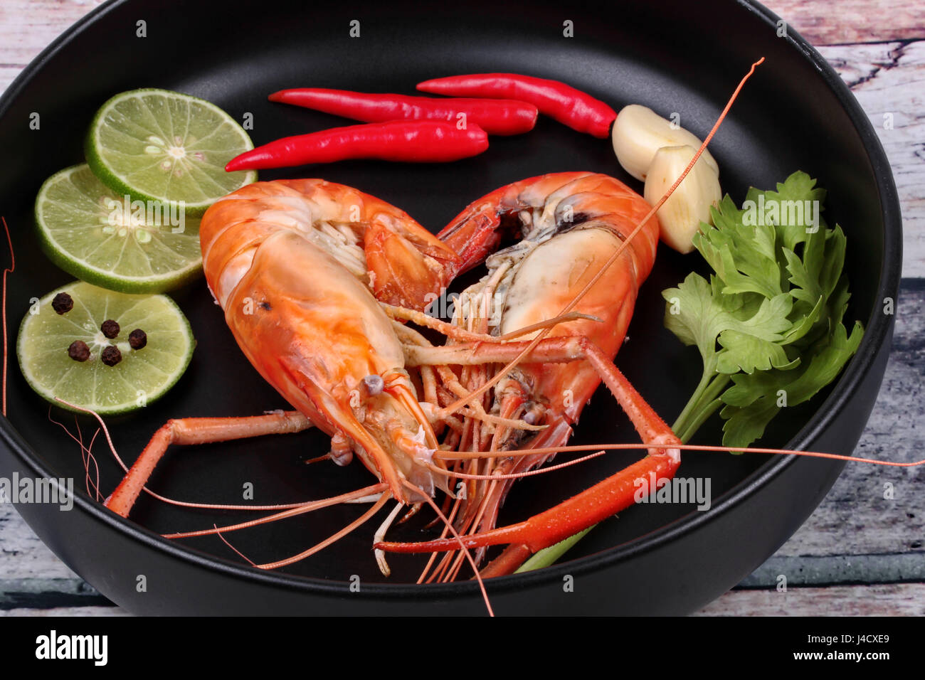 Ready streamed large fresh prawns in heart shape and spicy sour herb ...