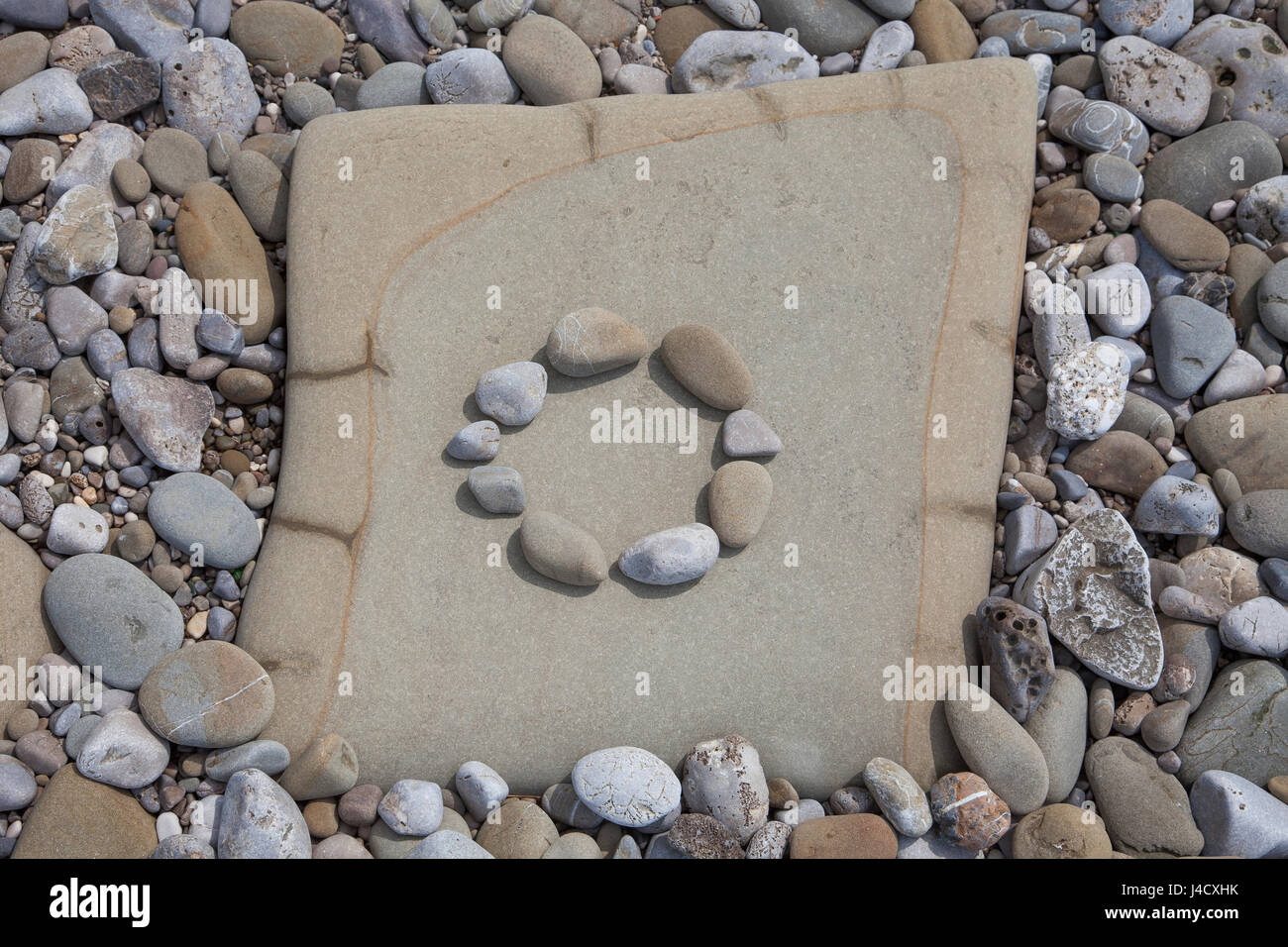 hand made circle of stones on rock frame on beach Stock Photo - Alamy