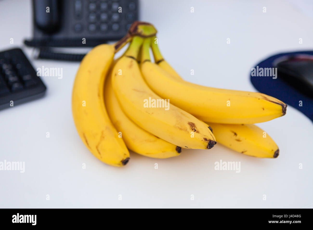 Healthy eating at work, bananas on the desk Stock Photo - Alamy