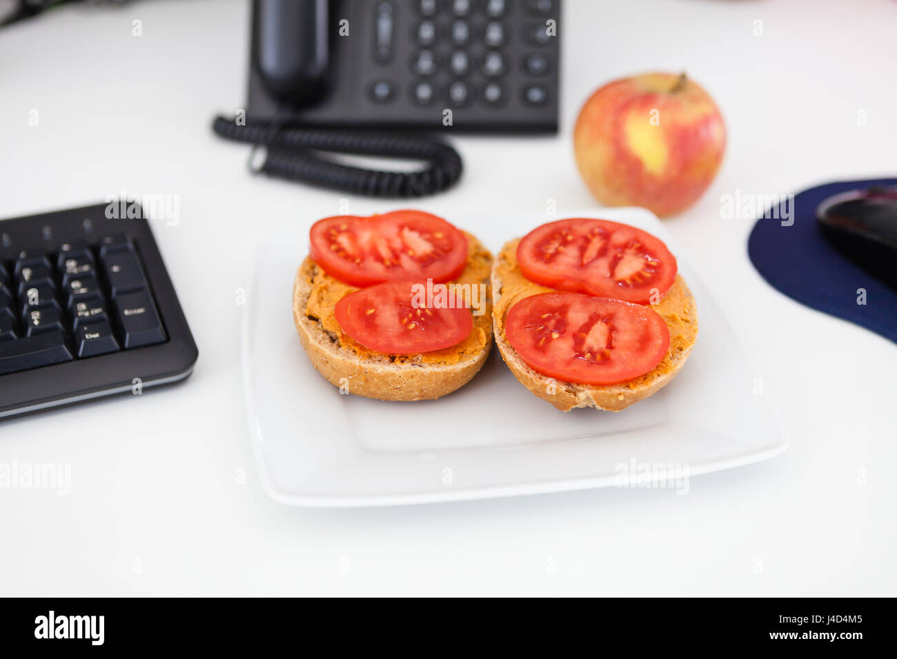 Sandwich and computer keyboard at table in office hi-res stock ...
