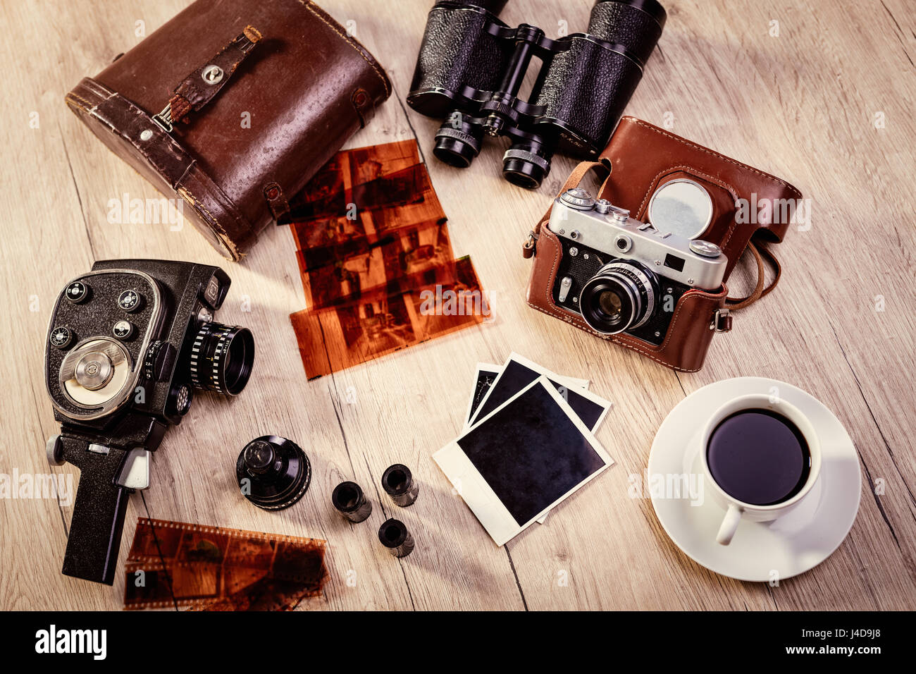 Top view of a old-fashioned cameras with films and lens. Next on table ...