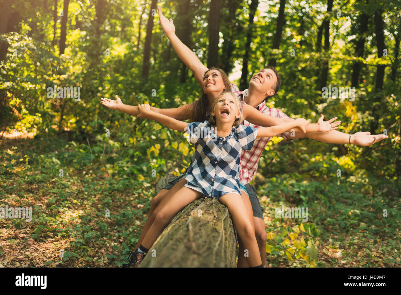 Young crazy family having fun during the walk through forest. They are ...