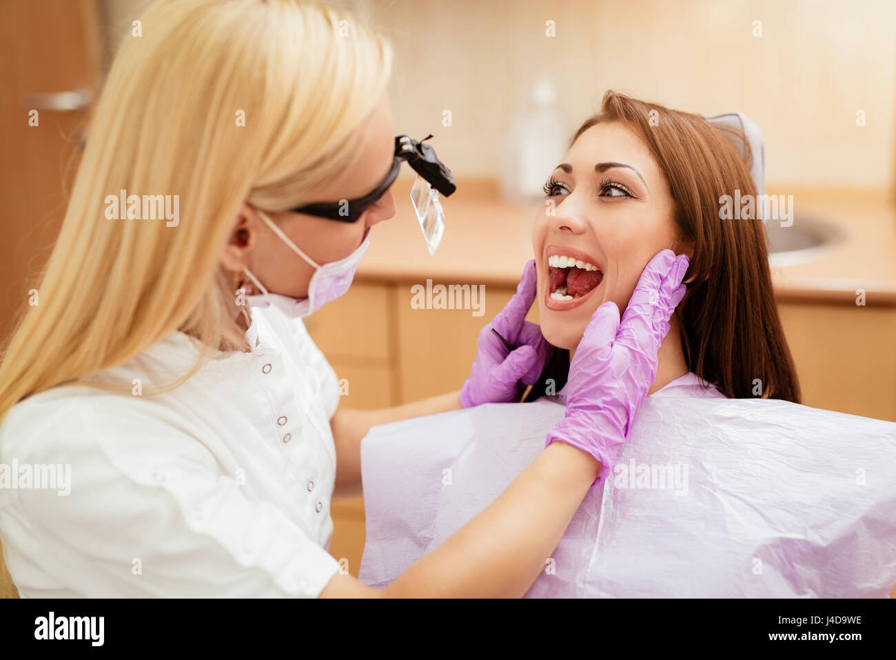 Beautiful young smiling woman at visit in the dentist office. She is ...