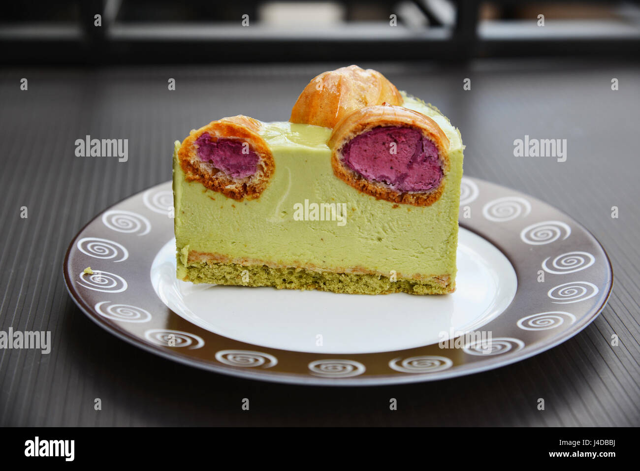 Piece of pistachio cake with a profitroles Stock Photo - Alamy