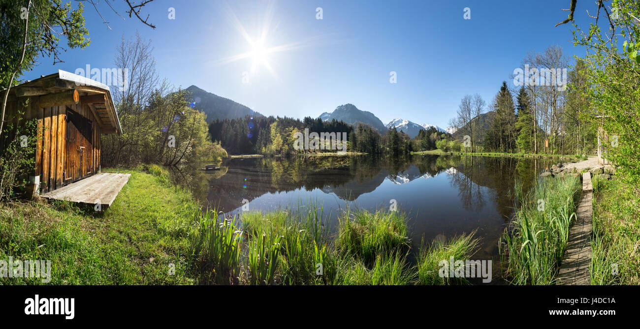 Log cabin at alpine lake and snow-covered mountains at sunrise Stock ...