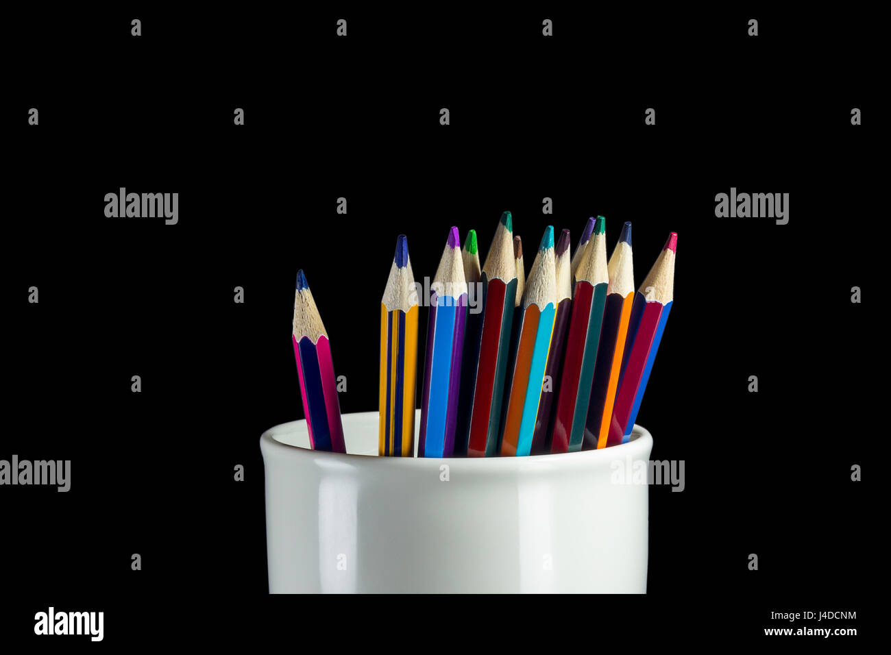 Sharp tips of colored pencils sharpen, on a dark wooden background ...