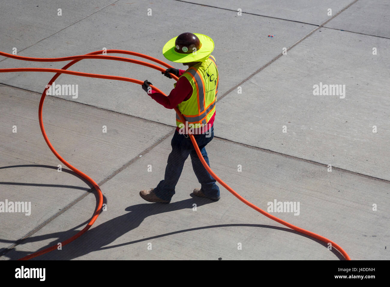 Tucson, Arizona - An electrical worker handles cables in the hot sun at ...