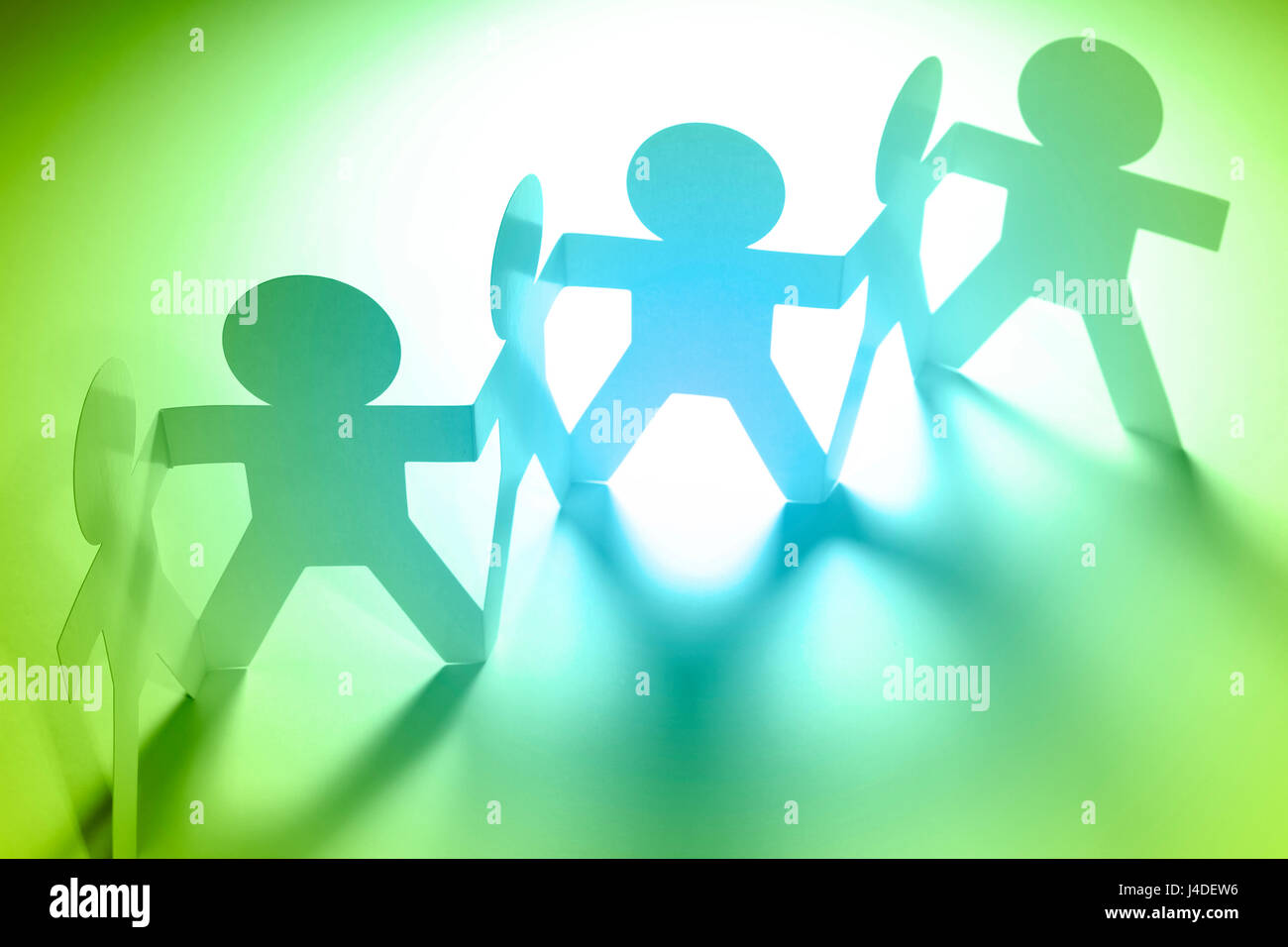 Team of paper chain people holding hands together Stock Photo - Alamy