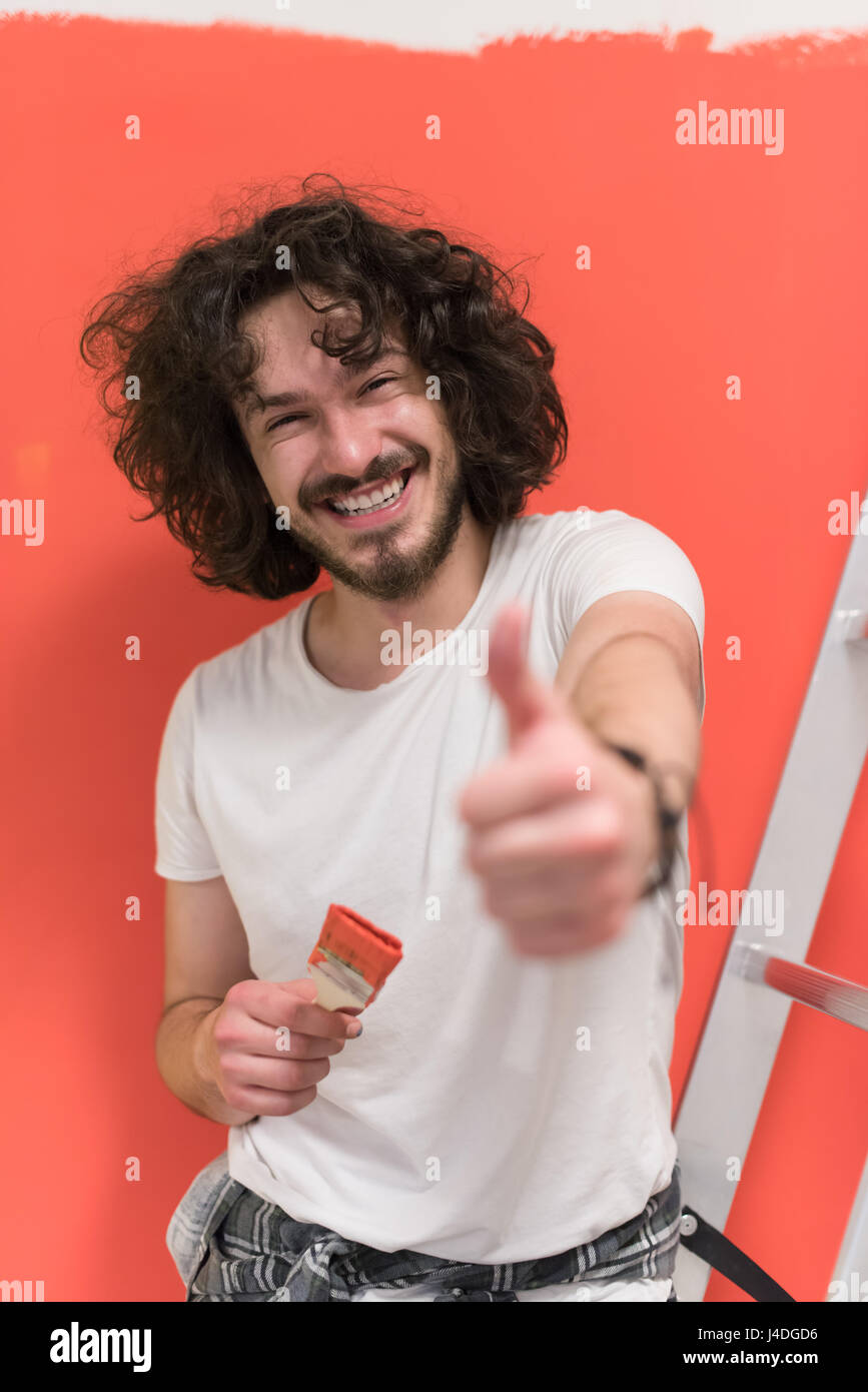 Portrait of a beautiful young man with funny hair and brush over color ...