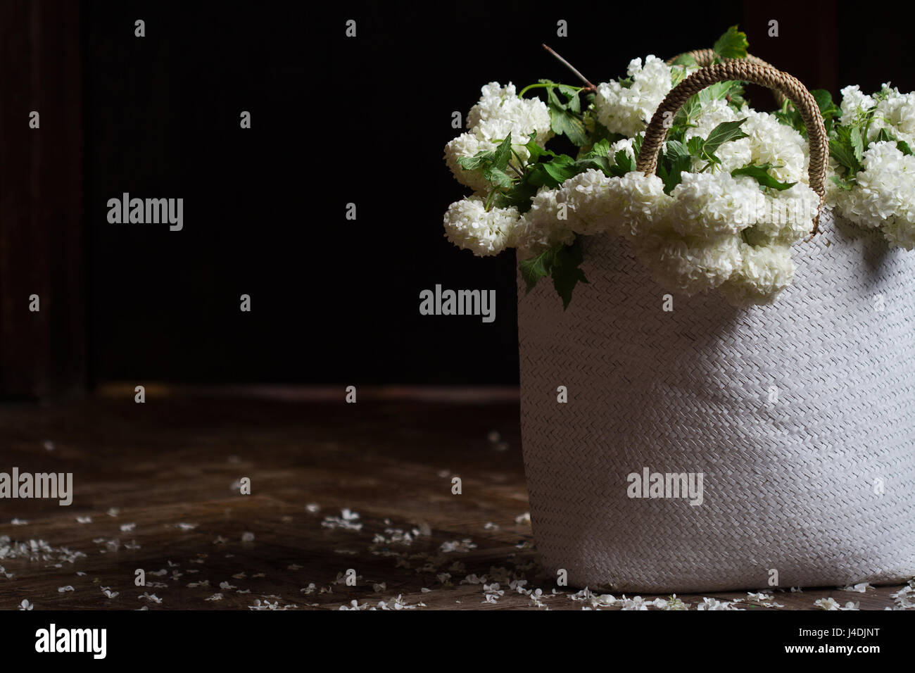 side view closeup of wicker bag with knitted handles full of white ...