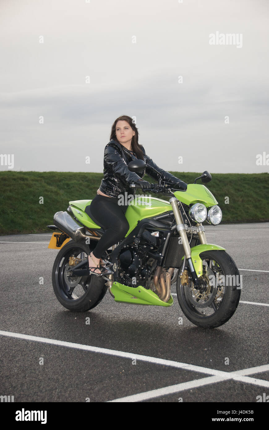 Brunette girl on a Triumph Street Triple motorcycle in a car aprk Stock ...