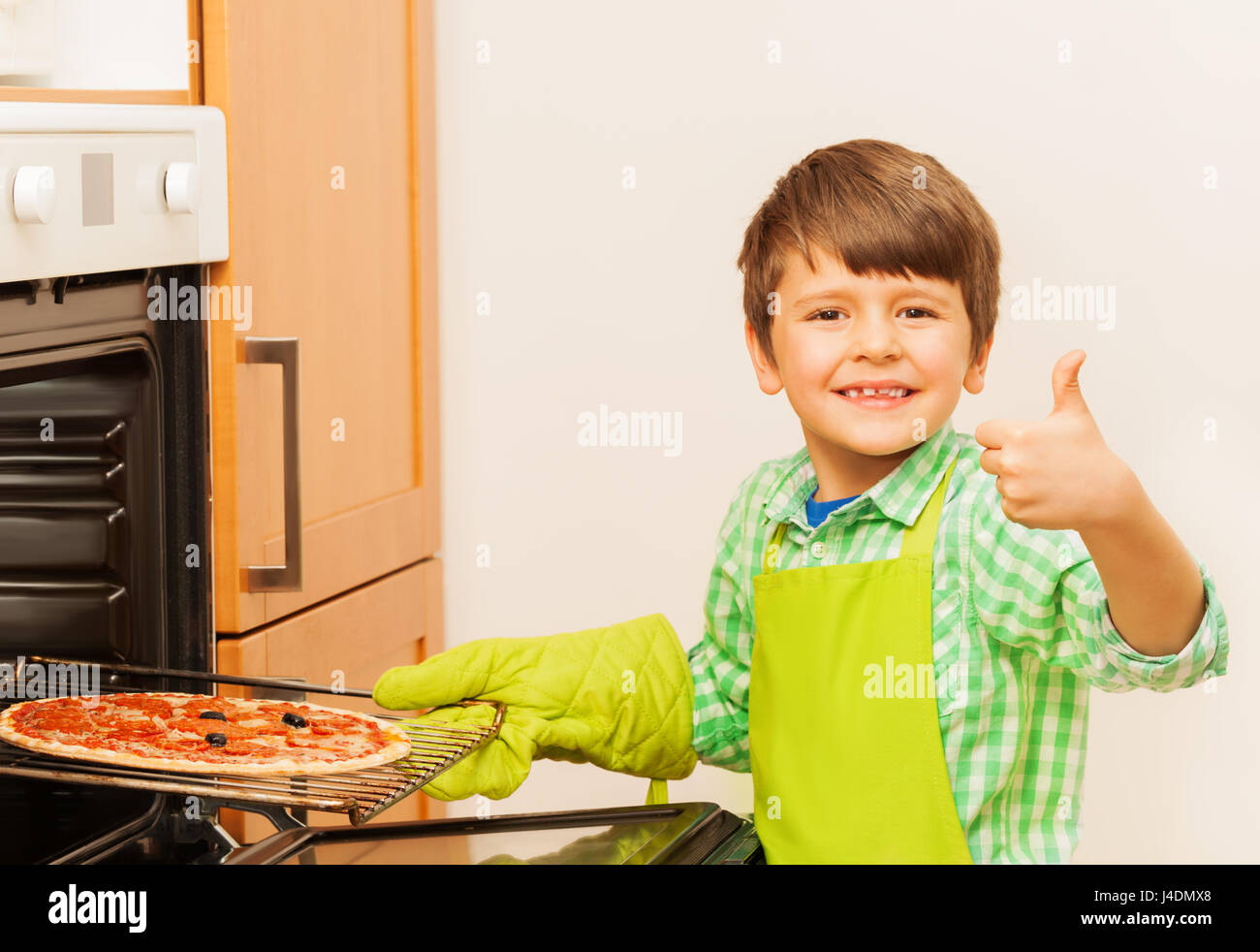 Happy kid boy cooking homemade pizza in the oven Stock Photo - Alamy