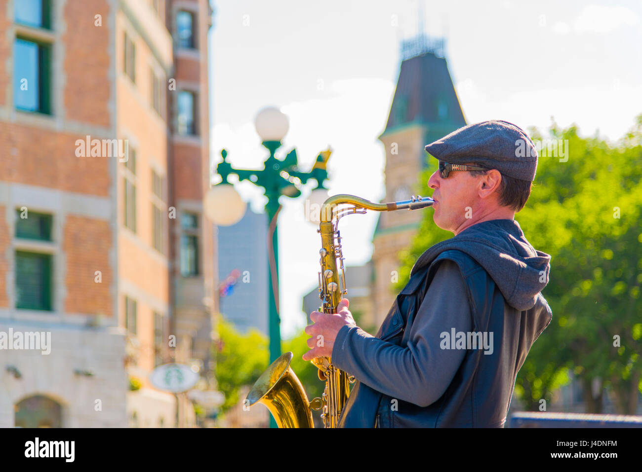 A saxophone musician in front of the Chateau Frontenac Hotel in Quebec ...