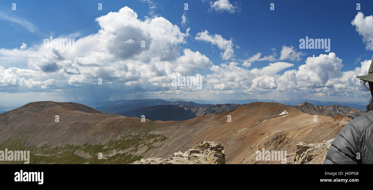 the edge of a woman from behind looking at Mount Bross and Mount ...