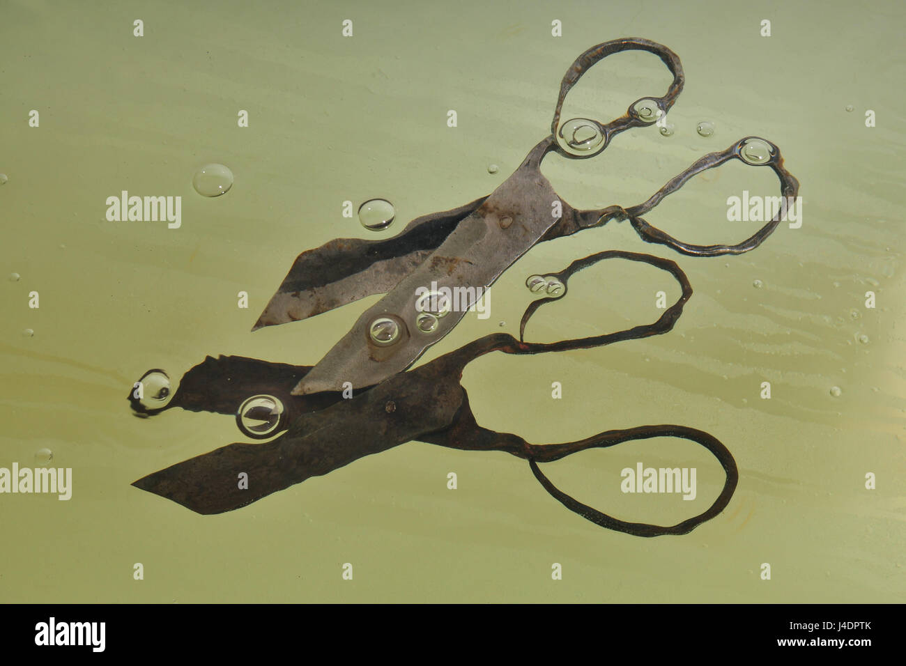 Old vintage metal scissors in water, silhouettes distorted by water ...