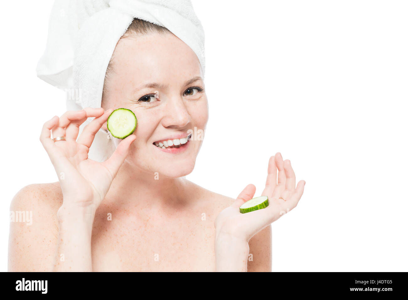 Happy woman with freckles on the skin with cucumbers for face mask ...