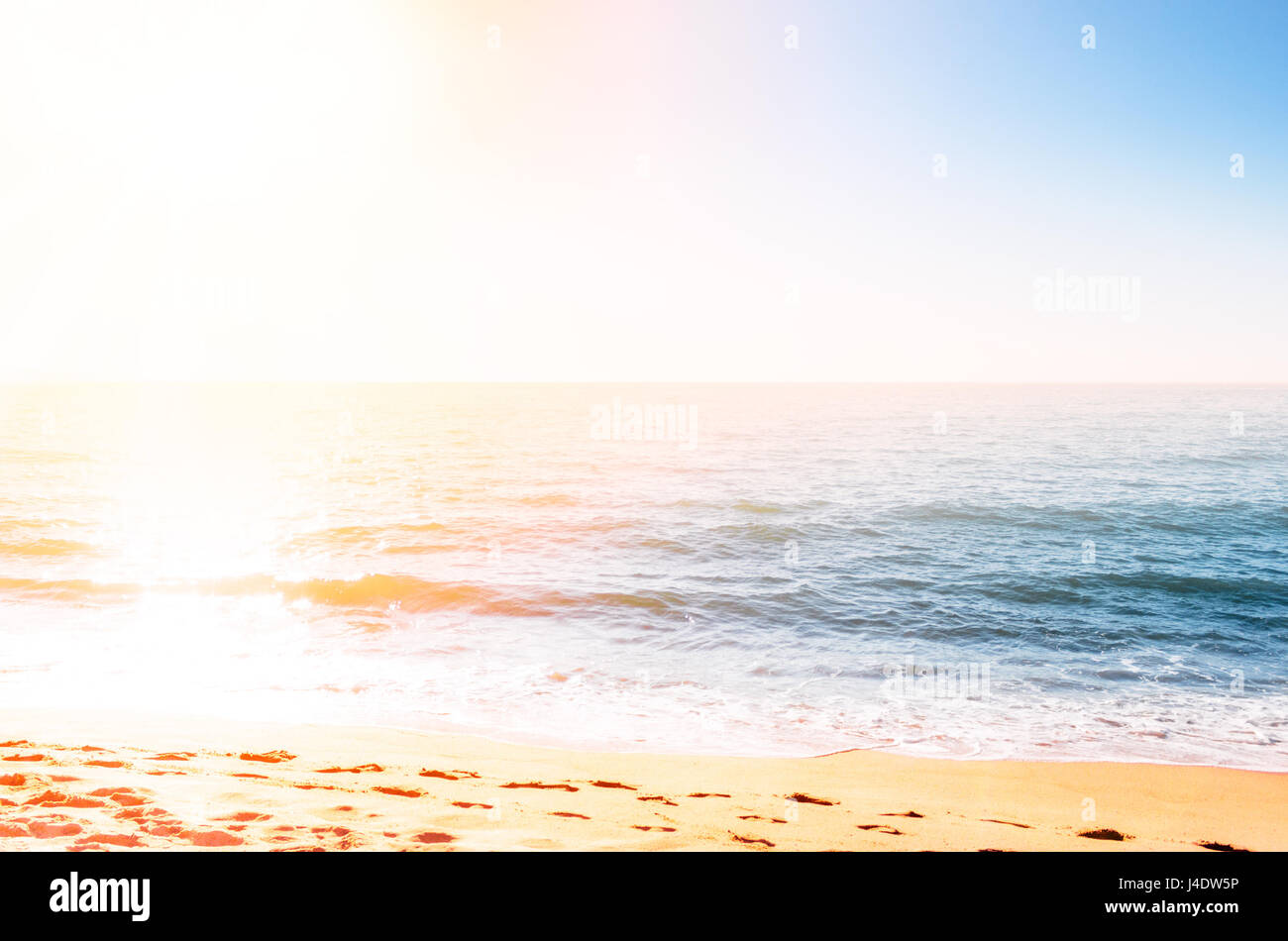 Sand coastline against bright shining sun Stock Photo - Alamy