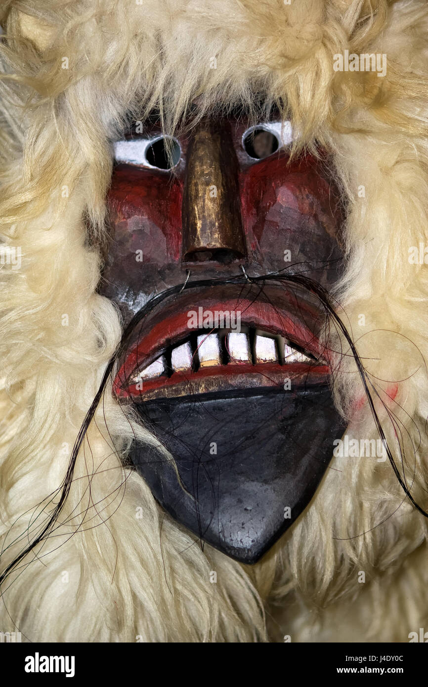 Closeup of a handmade, carved and painted mask made of wood and wool ...
