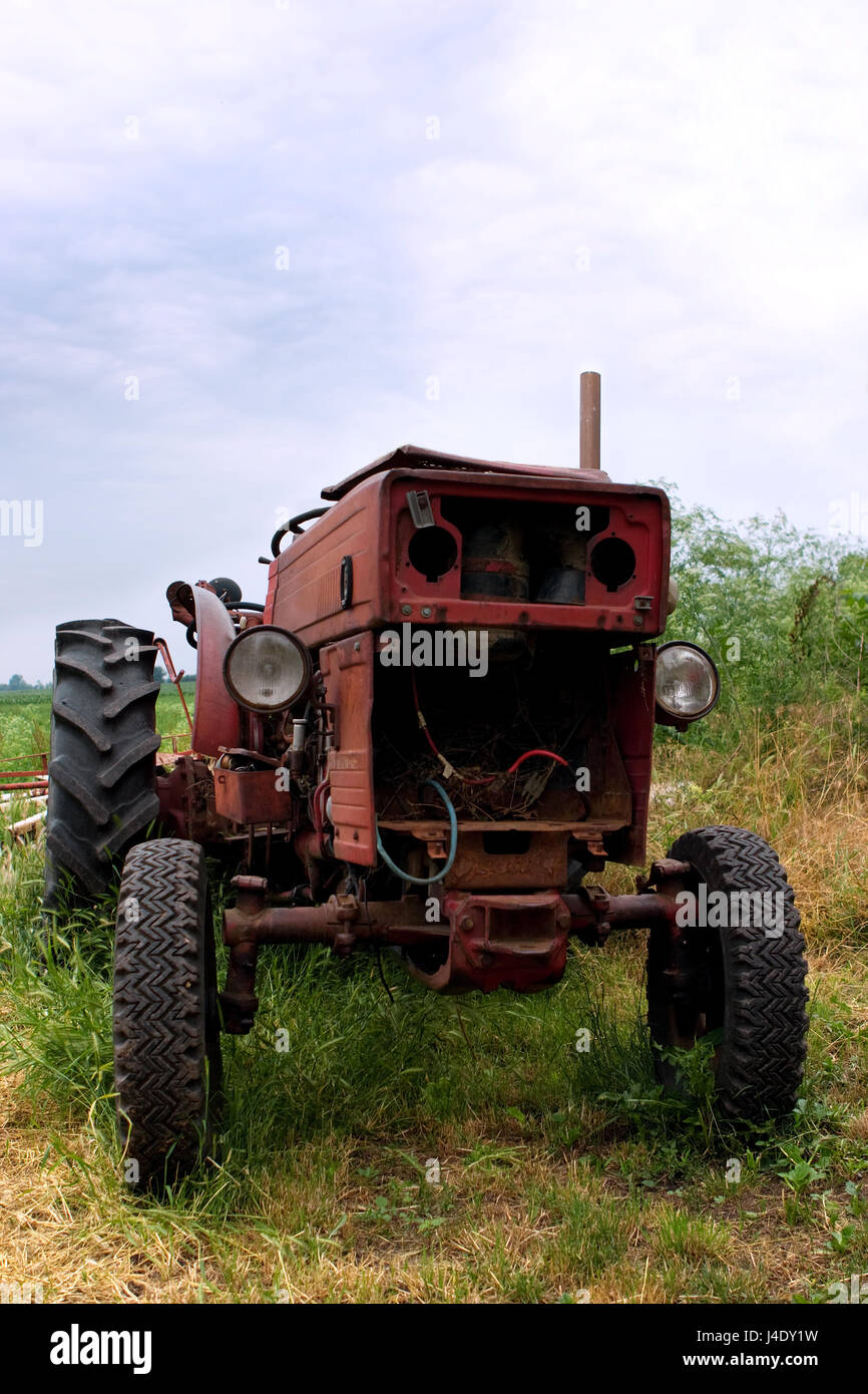 Rusty red East European tractor abandoned in the nature Stock Photo - Alamy