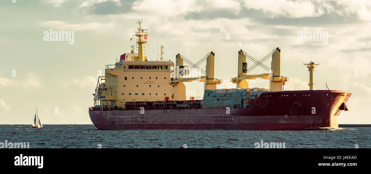 Red cargo ship moving entering the port of Riga Stock Photo - Alamy