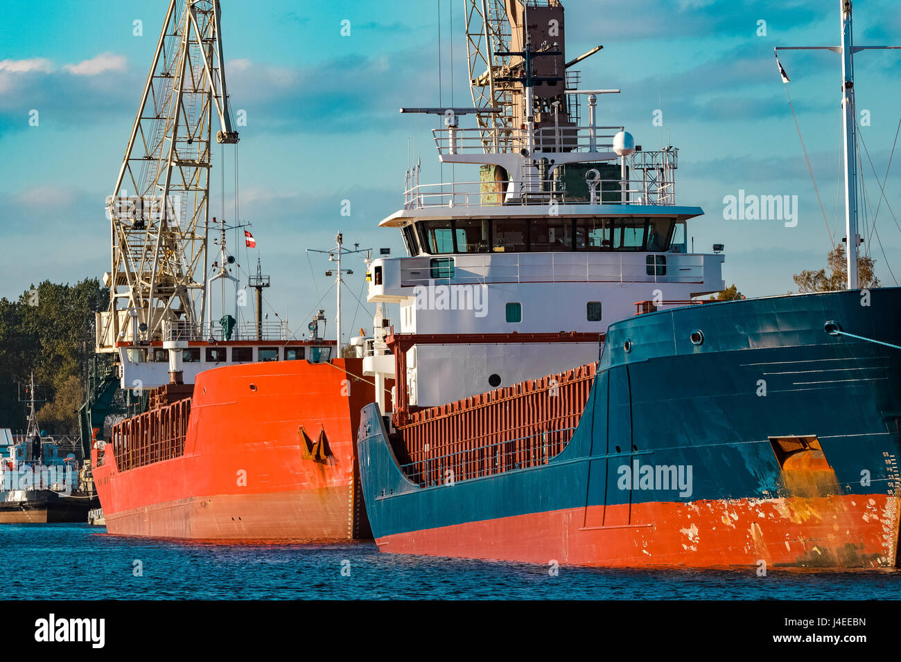 Blue cargo ship moored and loading at the port Stock Photo - Alamy