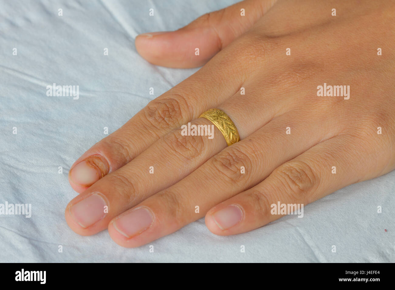 detail of one hand with gold ring in finger woman Stock Photo - Alamy