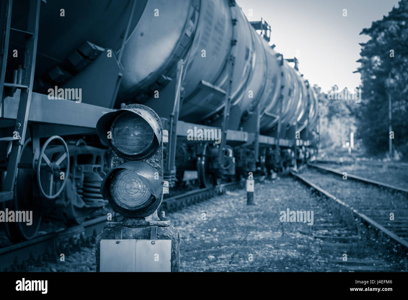 Railroad traffic light and freight train on behind Stock Photo - Alamy