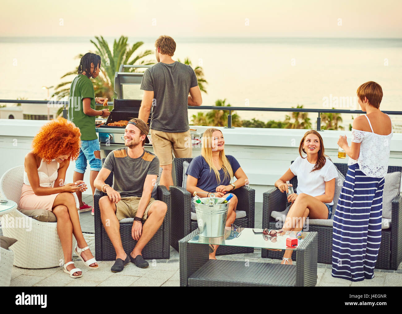 Attractive group of friends socialisng on a rooftop with a stuning ...