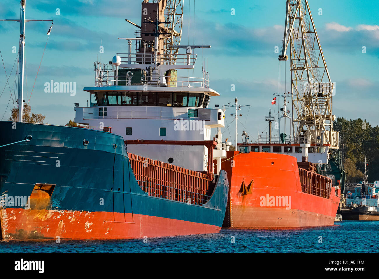 Blue cargo ship moored and loading at the port Stock Photo - Alamy