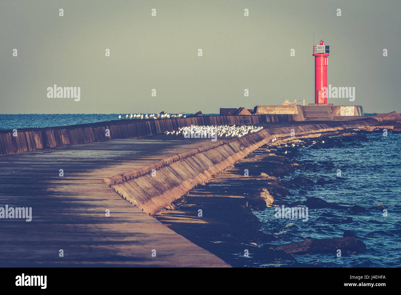 Red lighthouse on breakwater jetty at Baltic sea Stock Photo - Alamy