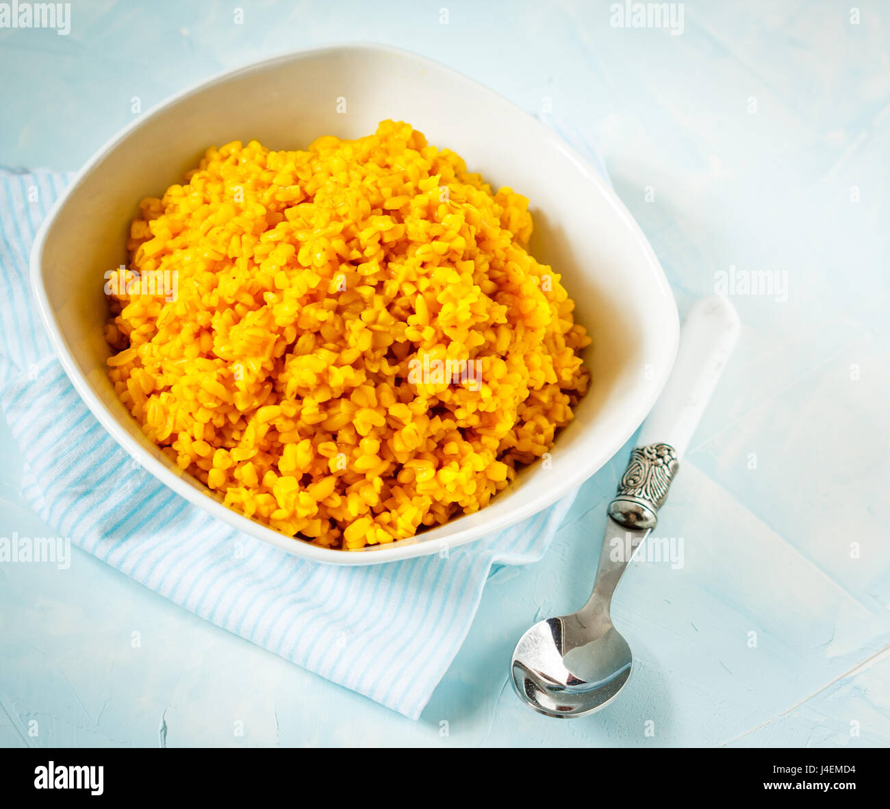 Boiled bulgur in a wooden bowl on a blue background. Love for a healthy ...