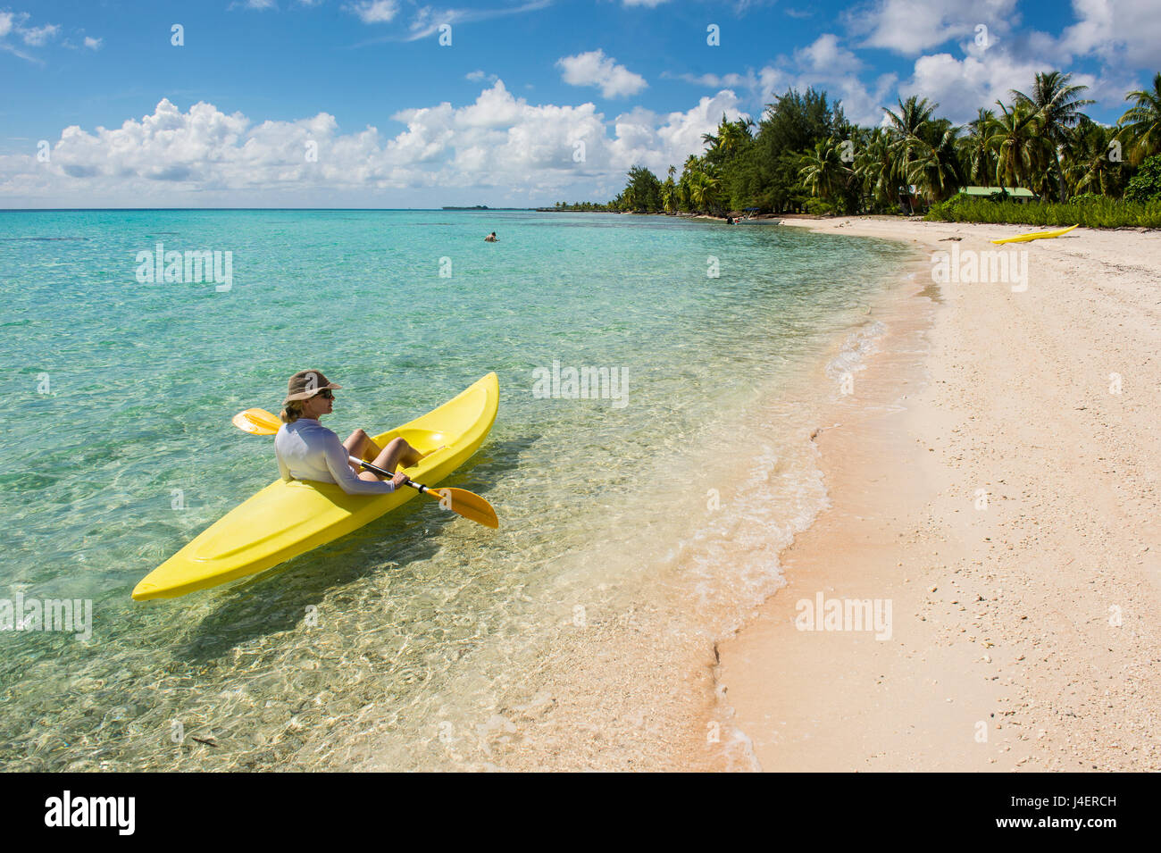 Woman kayaking in the turquoise waters of Tikehau, Tuamotus, French ...